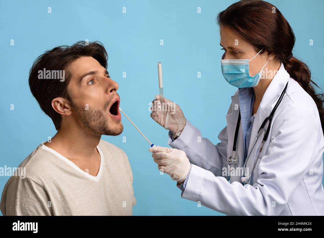 Female Nurse Holding Swab Making Oral PCR Coronavirus Test For Young ...