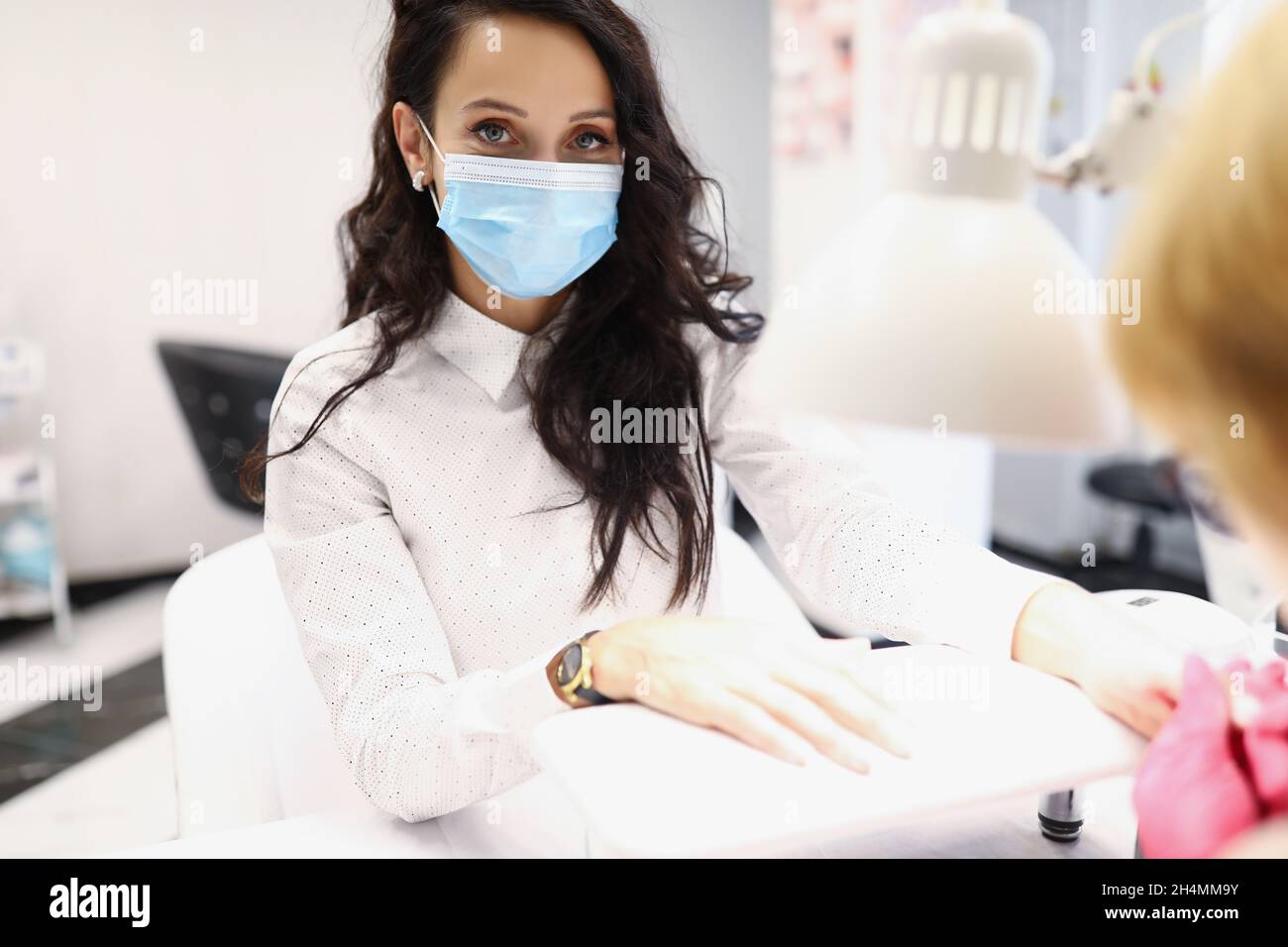 Brunette woman getting nails done Stock Photo - Alamy