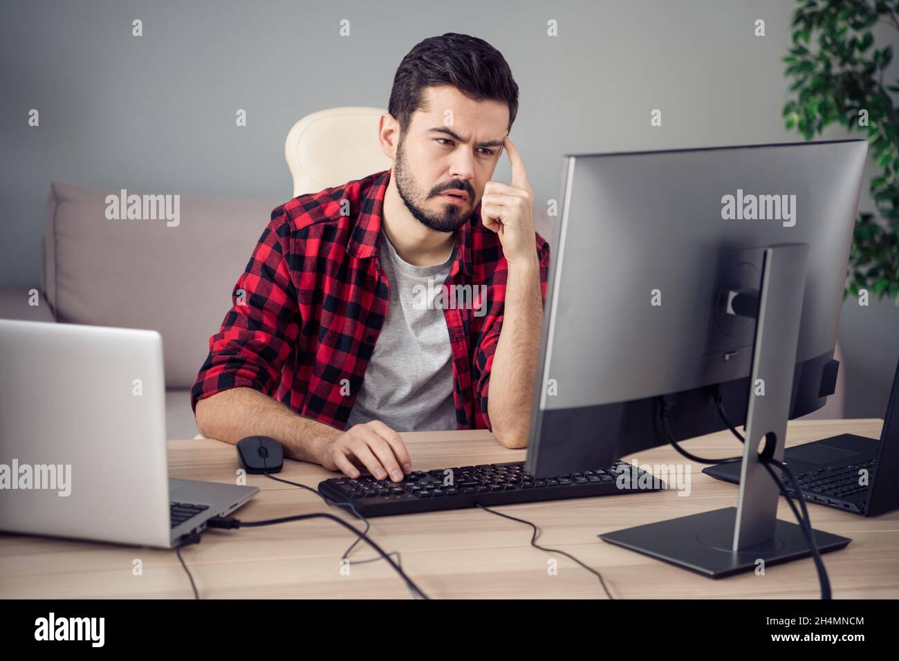 Photo of unhappy tired young man programmer browsing sit desk write ...