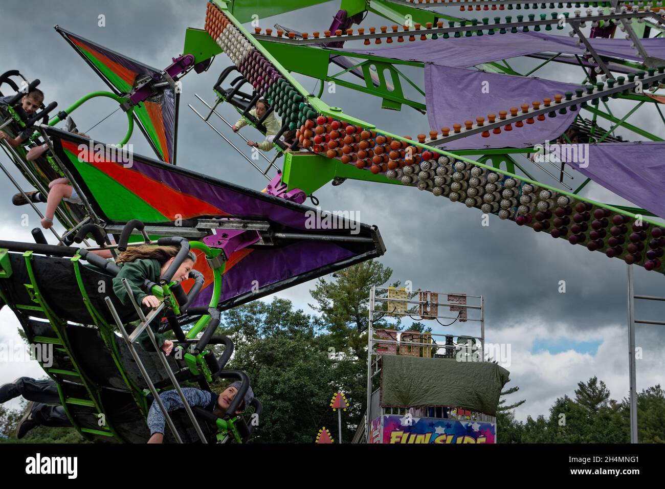A fully loaded kite ride with smiling children in the foreground ...