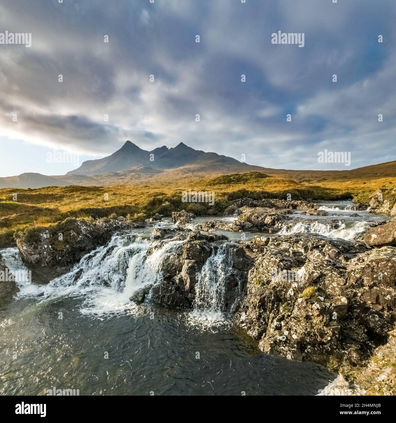 A waterfall on Allt Dearg Mor river with the Black Cuillin mountains in ...