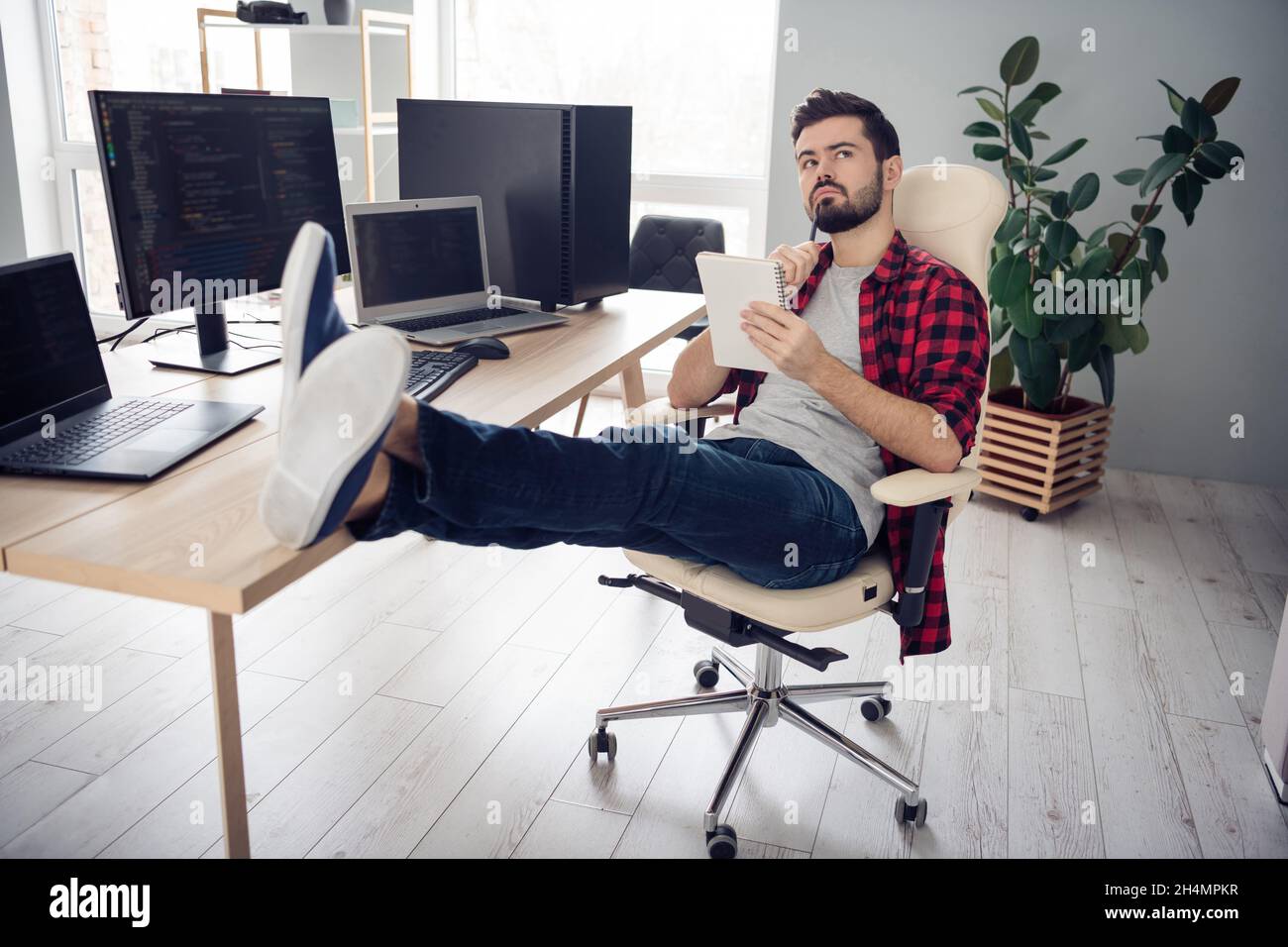 Full length photo of serious minded young man sit table write note ...