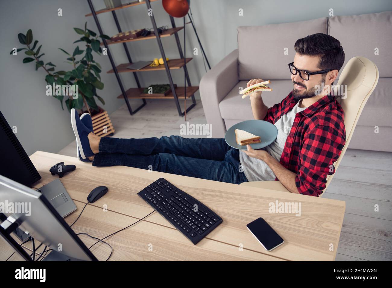 Portrait of attractive trendy cheery guy eating snack watching ...