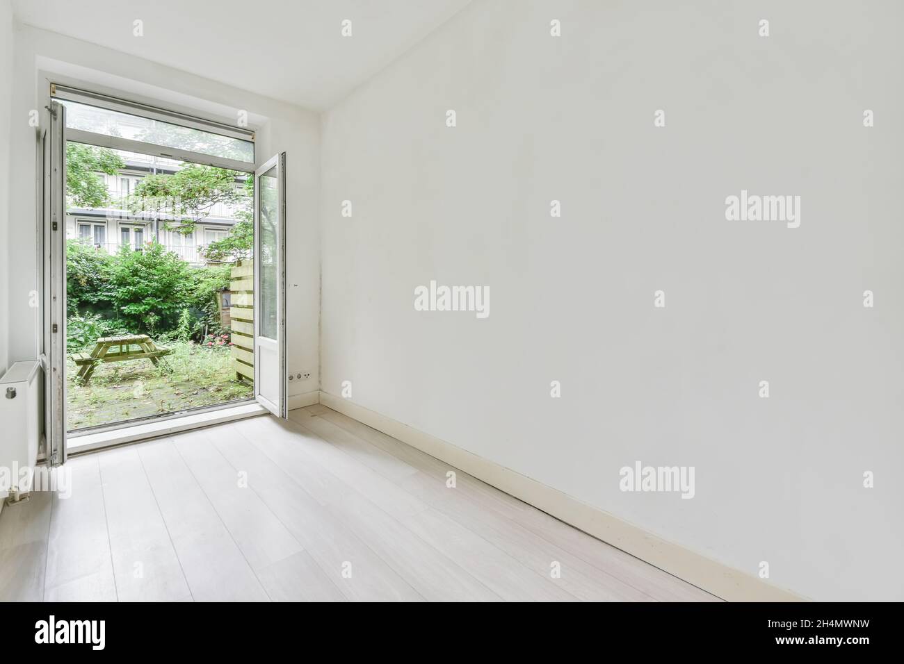 Beautiful image of an empty room with an excess to the garden area in a ...