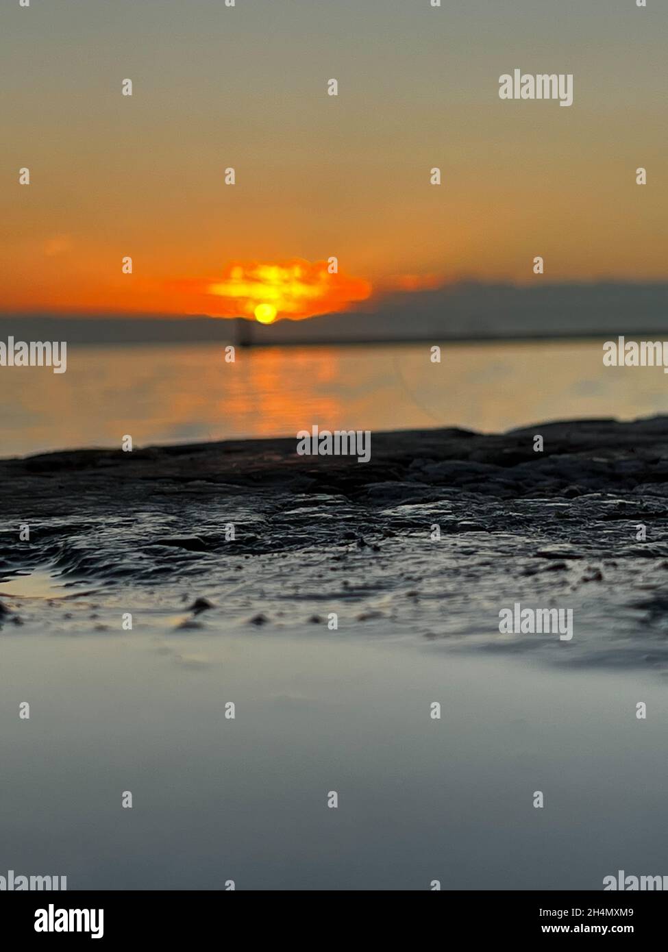 Tranqil scene of sunset in the sea Stock Photo - Alamy