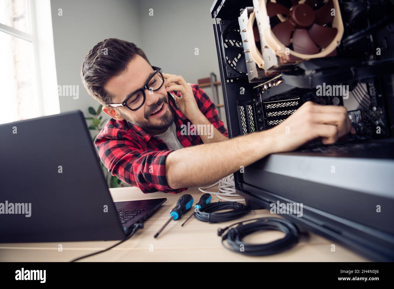 Portrait of attractive cheerful trendy guy contacting client upgrading ...