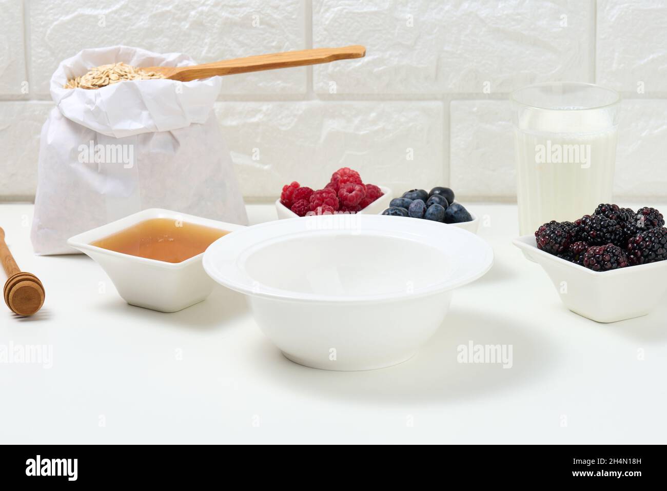 empty white round ceramic plate, oatmeal and fruit for cooking porridge ...