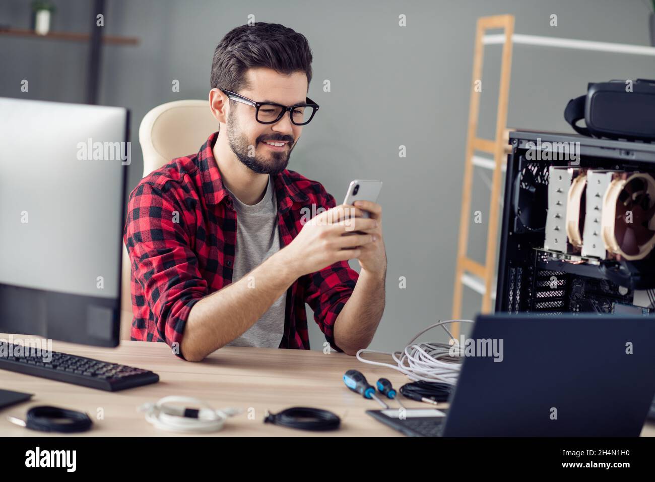 Portrait of attractive focused trendy cheerful guy engineer using ...