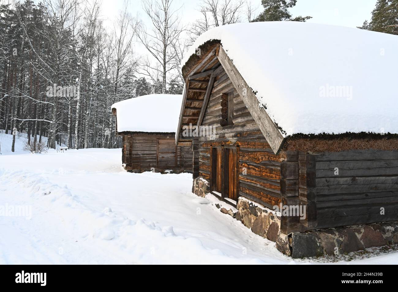 Snow-covered old wooden buildings with stone foundations in the middle ...