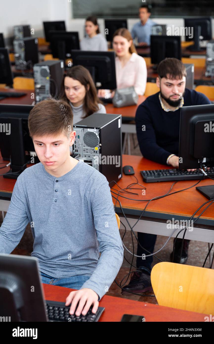 Group of people of different ages learning to use computers in ...
