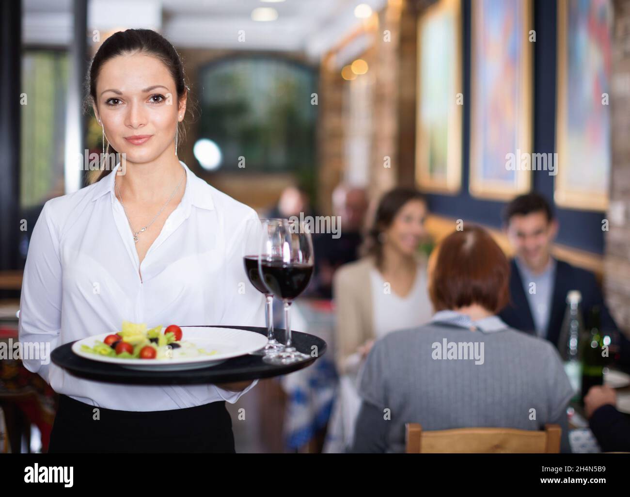 Professional waitress holding serving tray for restaurant guests Stock ...