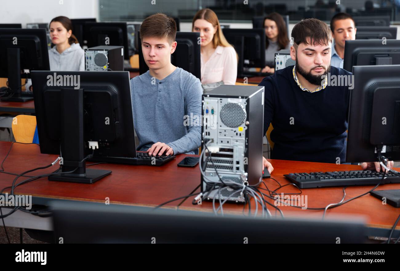 Group of people learning to use computers in classroom Stock Photo - Alamy