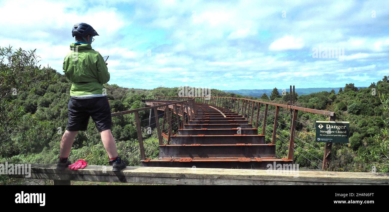 A cyclist uses her phone to photograph the 19th century Taonui rail viaduct, an historic place ...