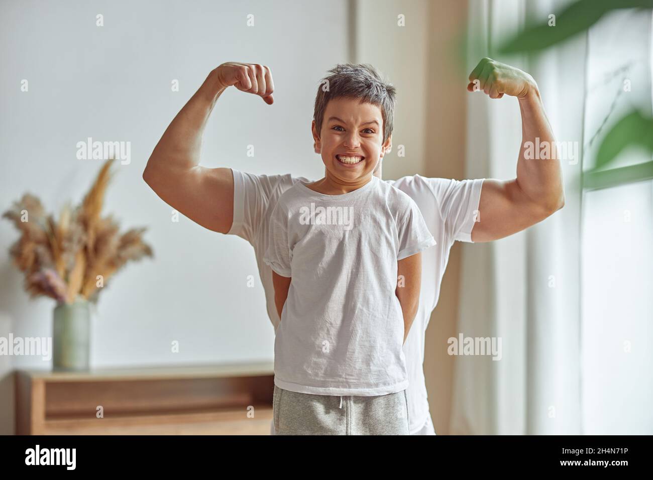 Happy boy taking exercising with strong father Stock Photo - Alamy