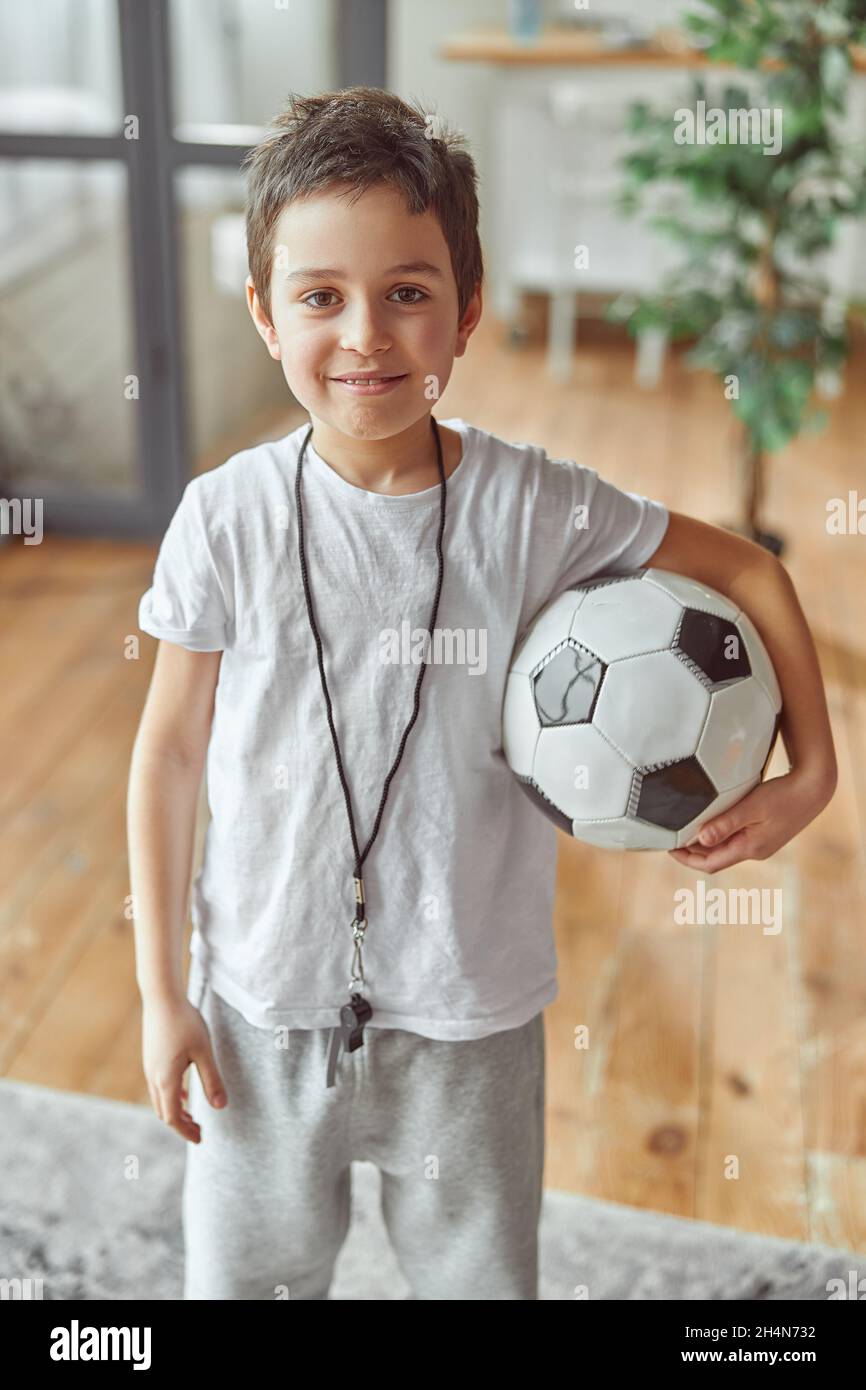 Happy boy playing football in living room Stock Photo - Alamy