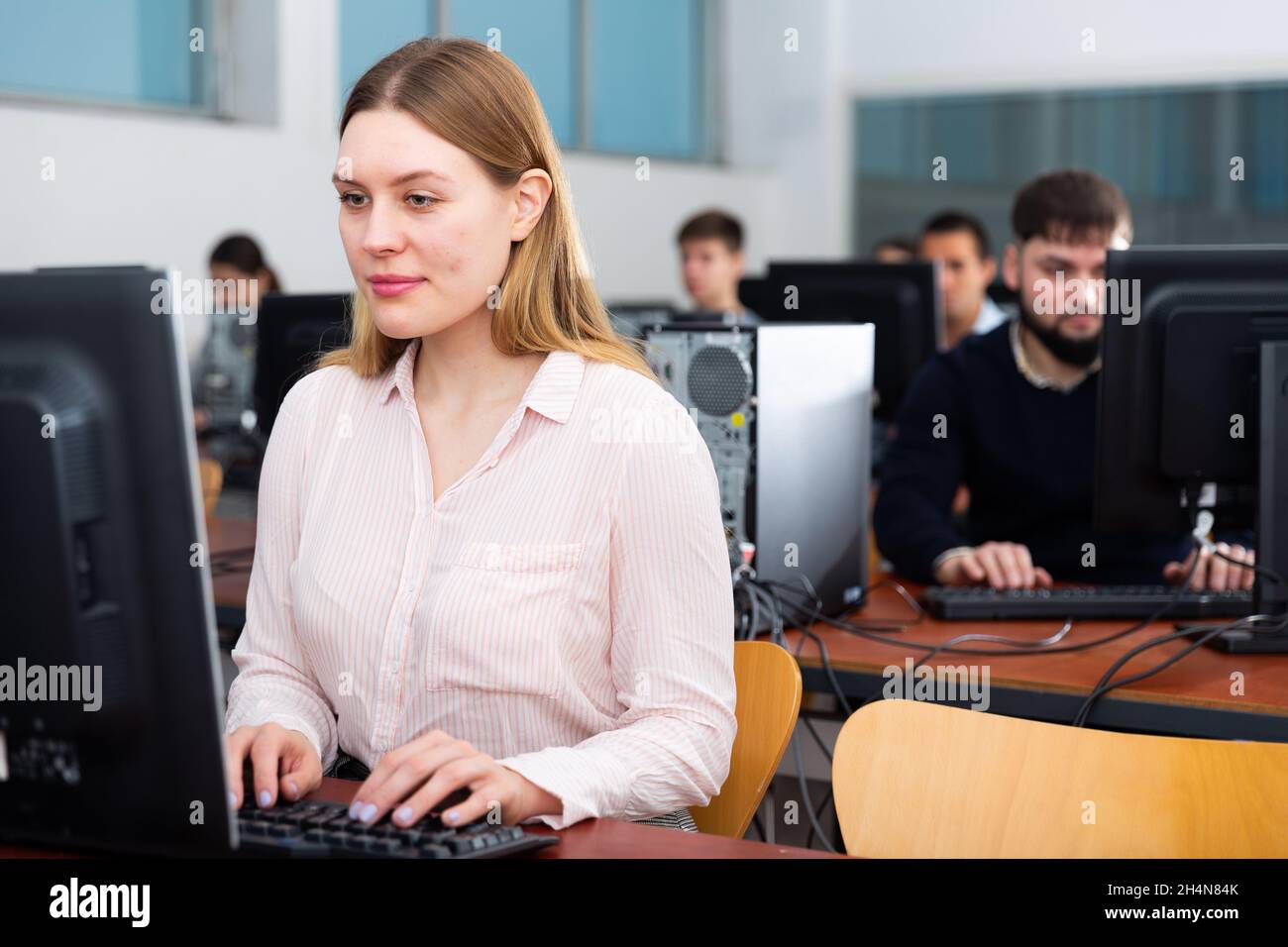 Group of people of different ages learning to use computers in ...