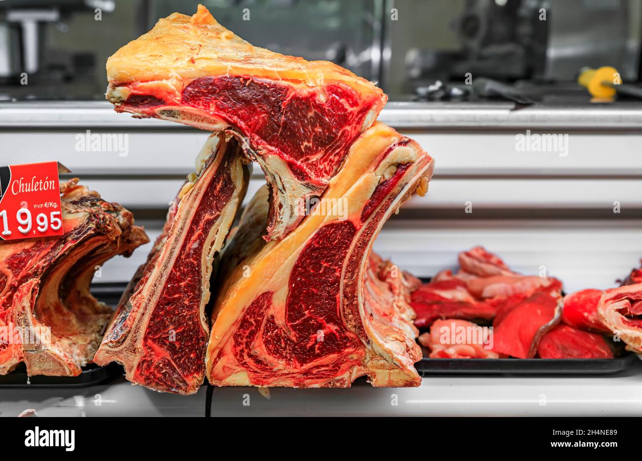 Whole pieces of bone-in ribeye roast on a meat counter at a butcher ...