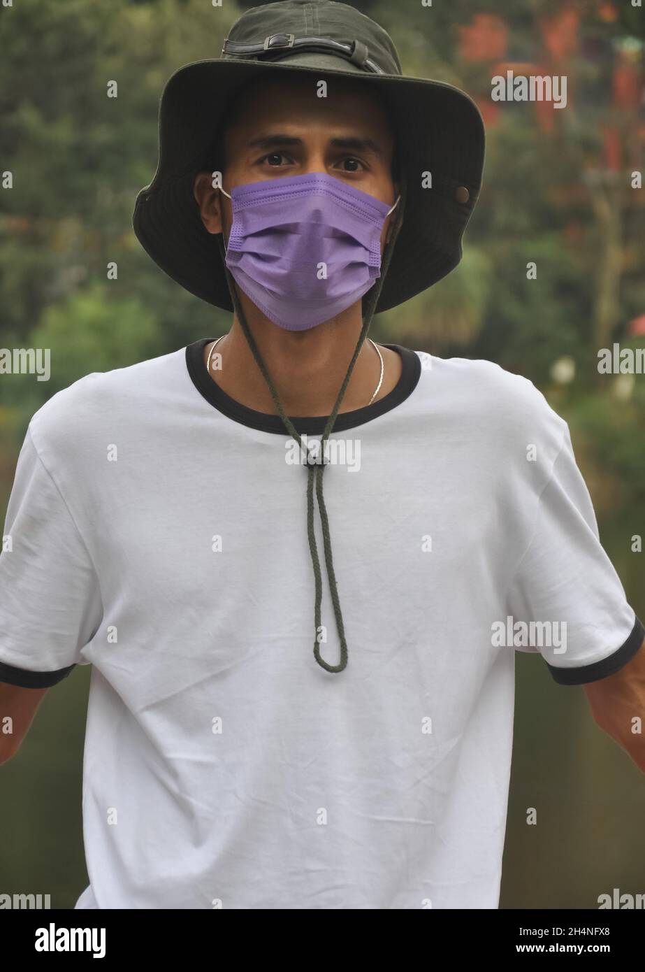Portrait of a good looking Indian young guy making shaka sign with his ...