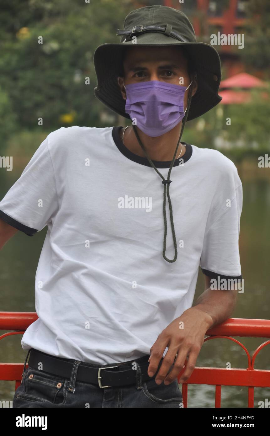 Portrait of a good looking Indian young guy making shaka sign with his ...