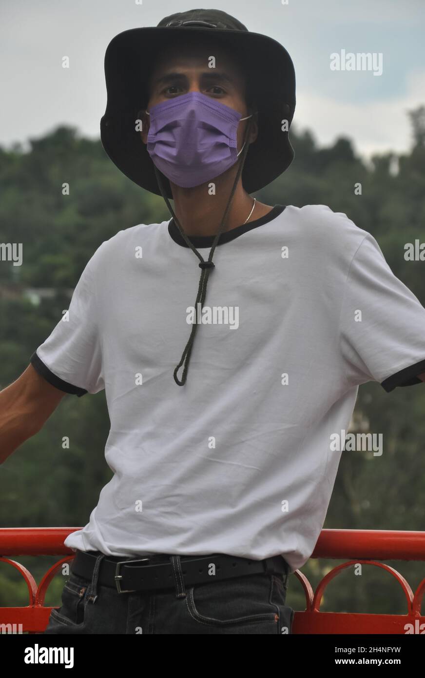 Portrait of a good looking Indian young guy making shaka sign with his ...