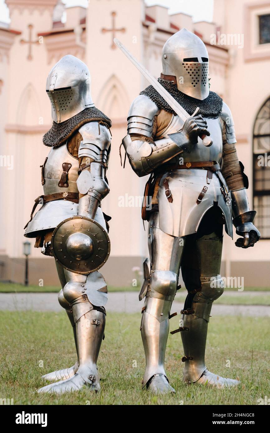 Two knights in armor on the background of a medieval castle.A medieval concept.Metallic texture ...