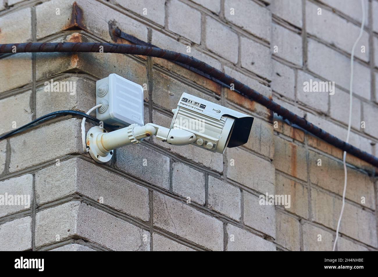 A surveillance camera is hanging on a brick wall Stock Photo - Alamy