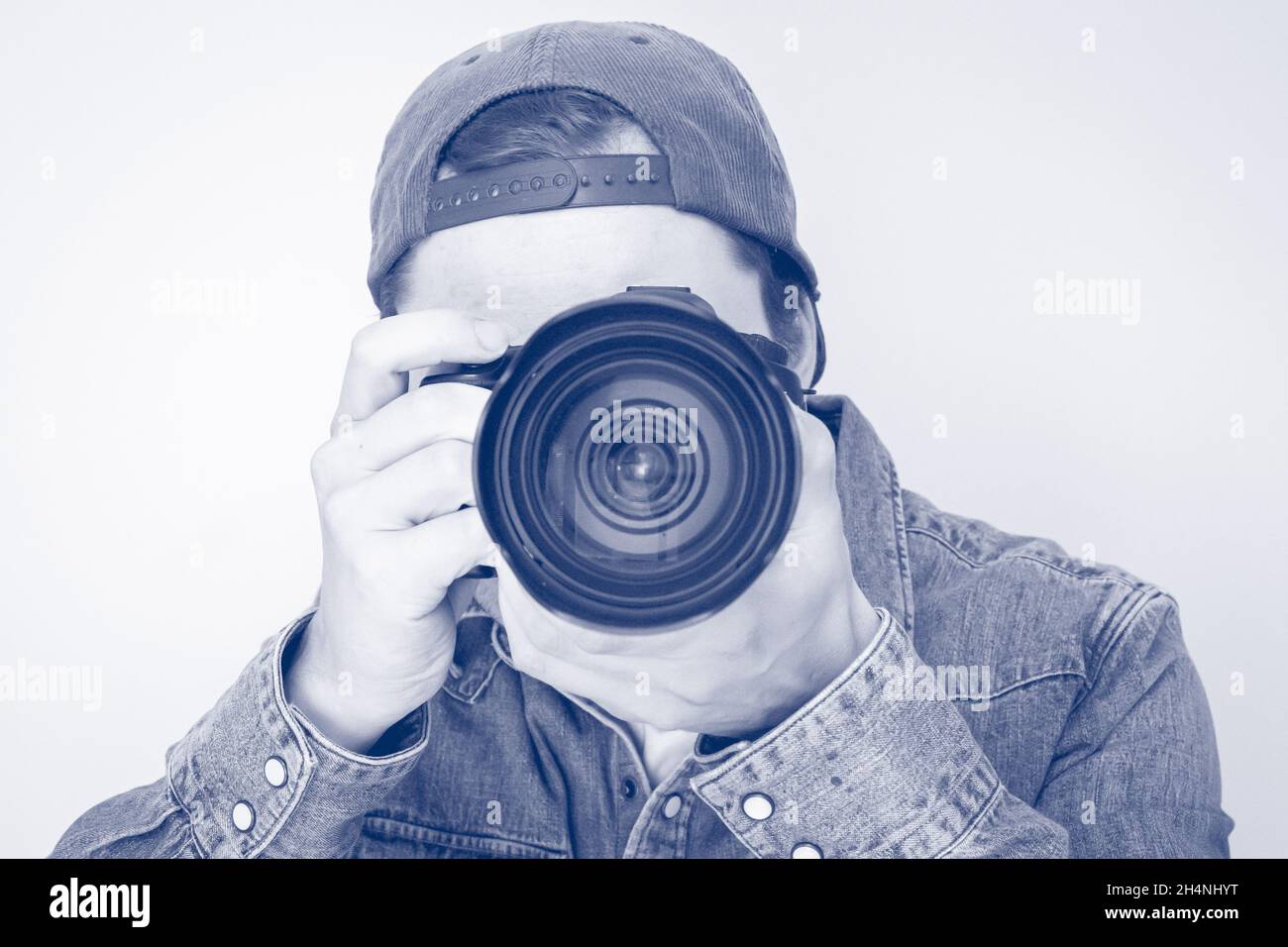 Monochrome shot of a young photographer with a proffessional camera ...