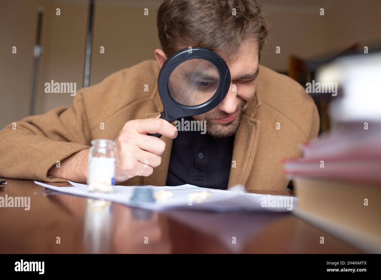 a detective searches for clues with a magnifying glass in the room ...