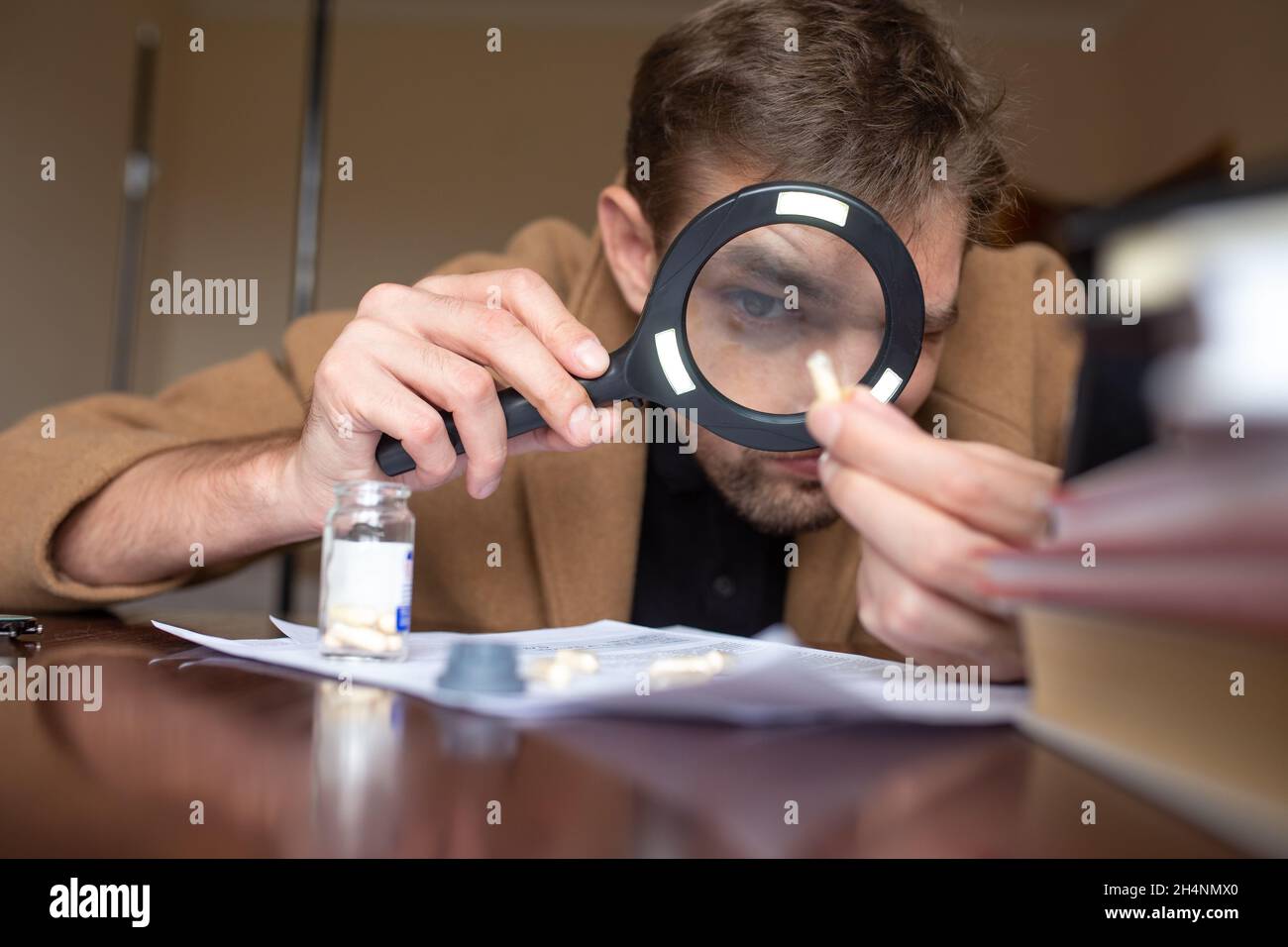 the investigator examines the evidence through a magnifying glass Stock ...
