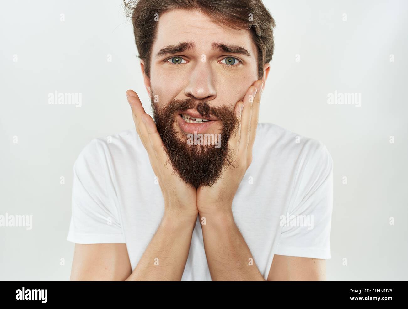 bearded man in a white t-shirt irritated facial expression Studio Stock ...
