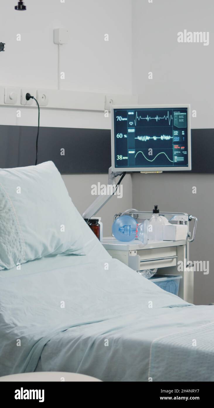 Hospital ward with bed and heart rate monitor at facility. Empty room ...