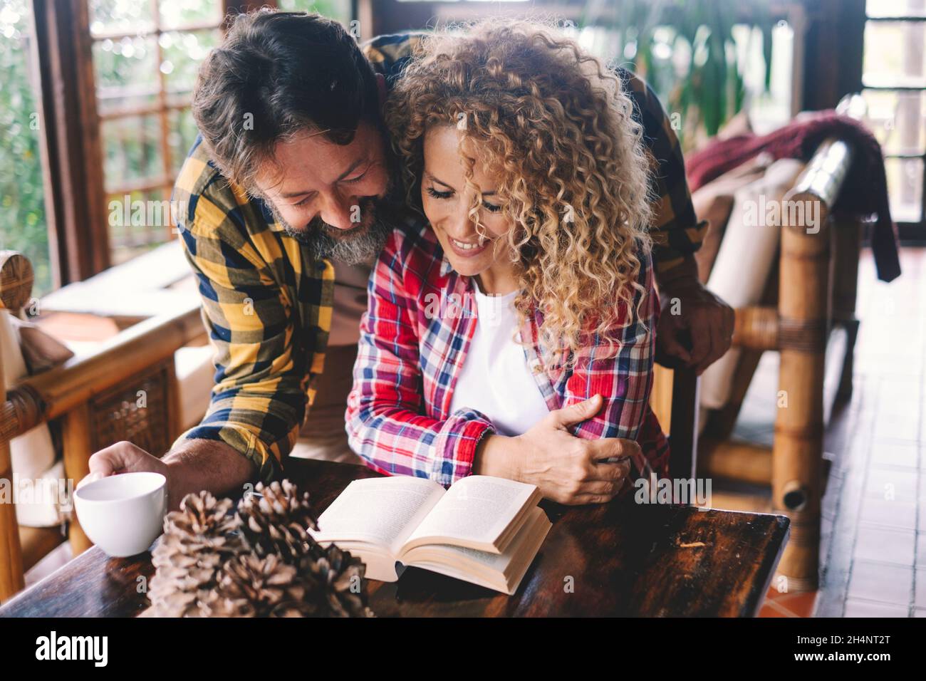 Happy relationship couple of adult at home reading a book and enjoy ...