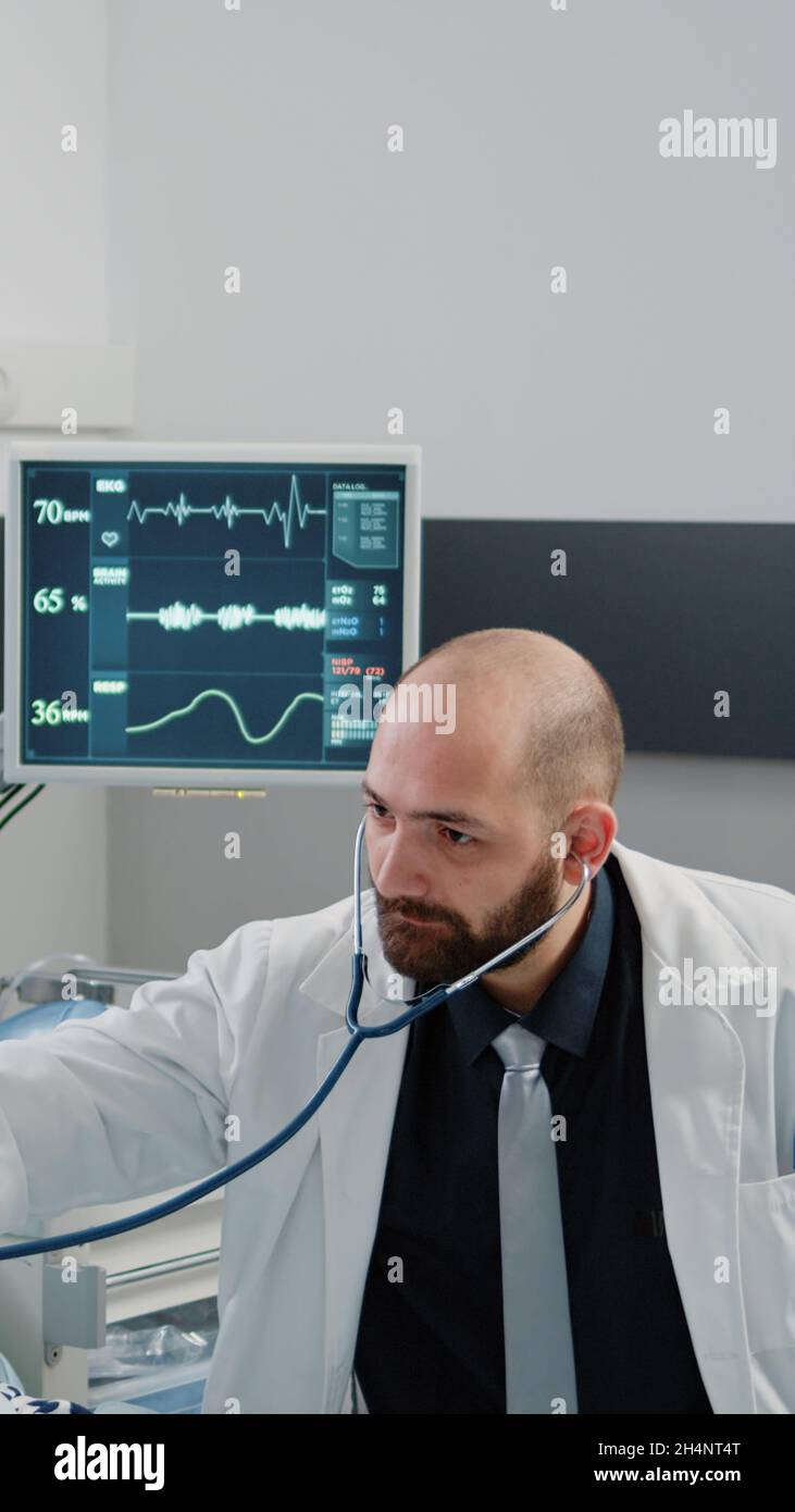 Doctor using stethoscope for heartbeat measurement on sick patient in ...