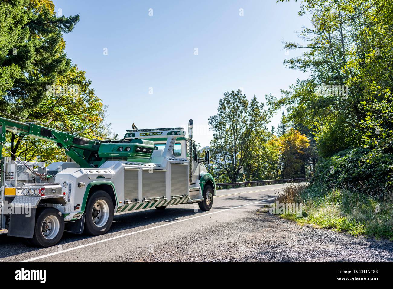 Green and white powerful mobile road assistant big rig towing semi ...