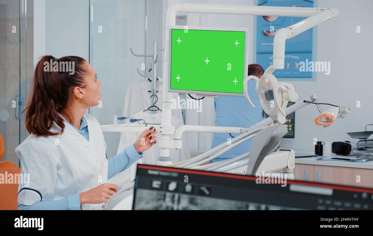 Woman analyzing green screen on monitor and teeth x ray for dental ...