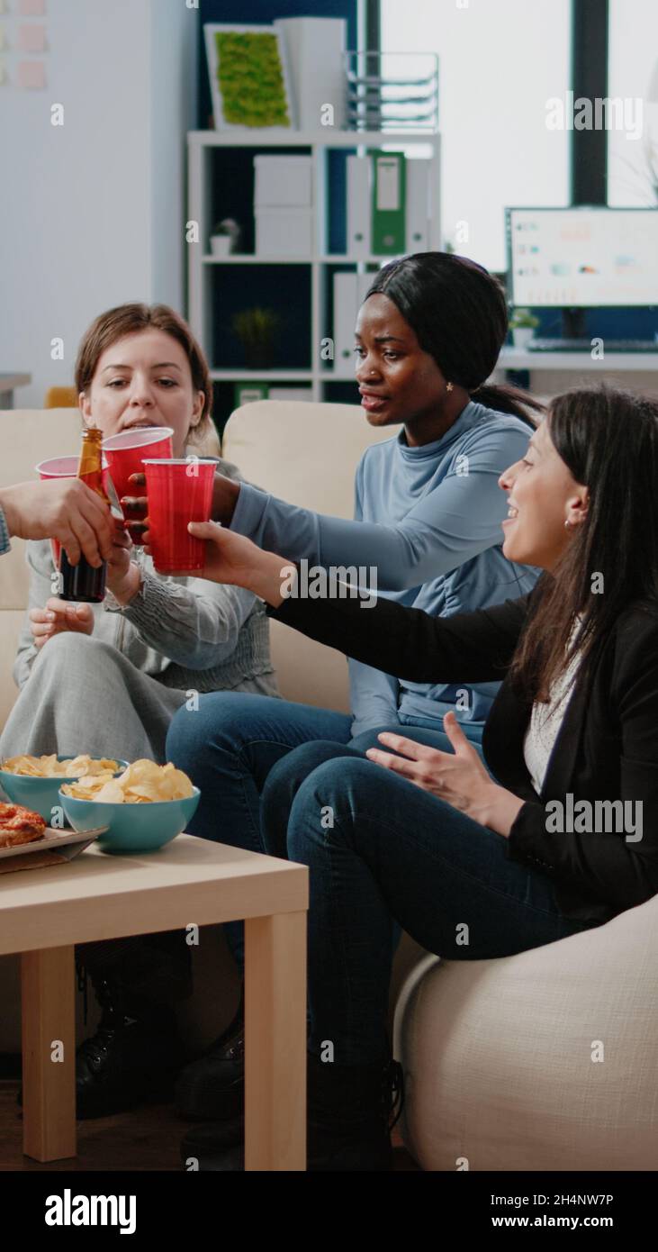 Workmates cheers with beer and alcoholic beverage after work at office ...