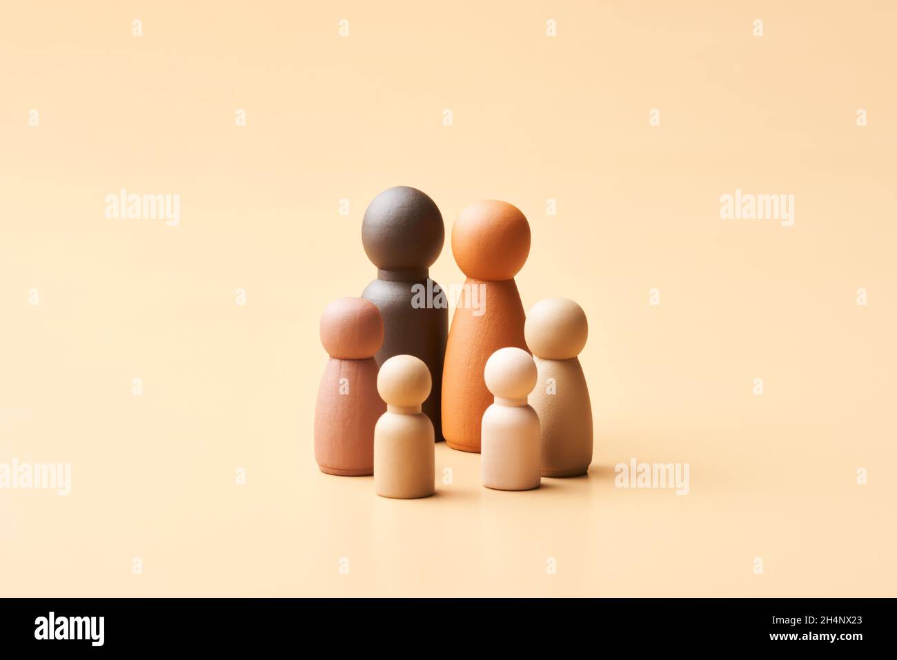 Simple wooden figurines of diverse parents and many kids representing ...