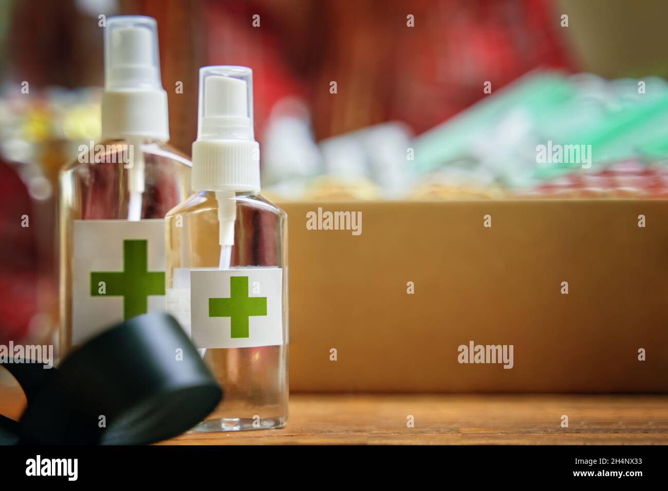 Two alcohol antiseptics with green cross logo on wooden table. Concept ...