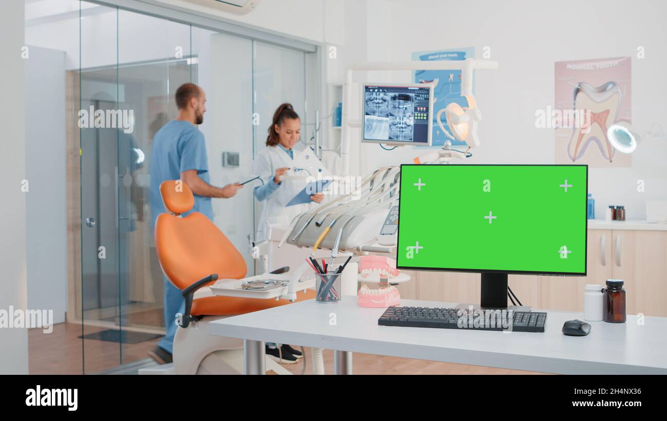 Horizontal green screen on computer in dentist office while specialists ...