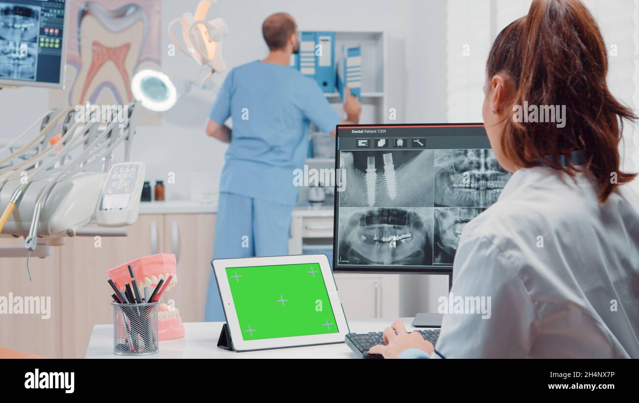 Orthodontist using horizontal green screen on tablet for oral care and ...
