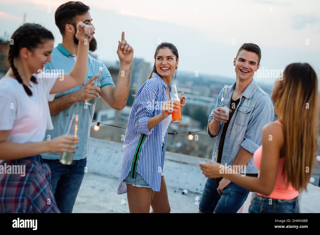 Enjoying rooftop party with friends. Group of happy people having fun ...