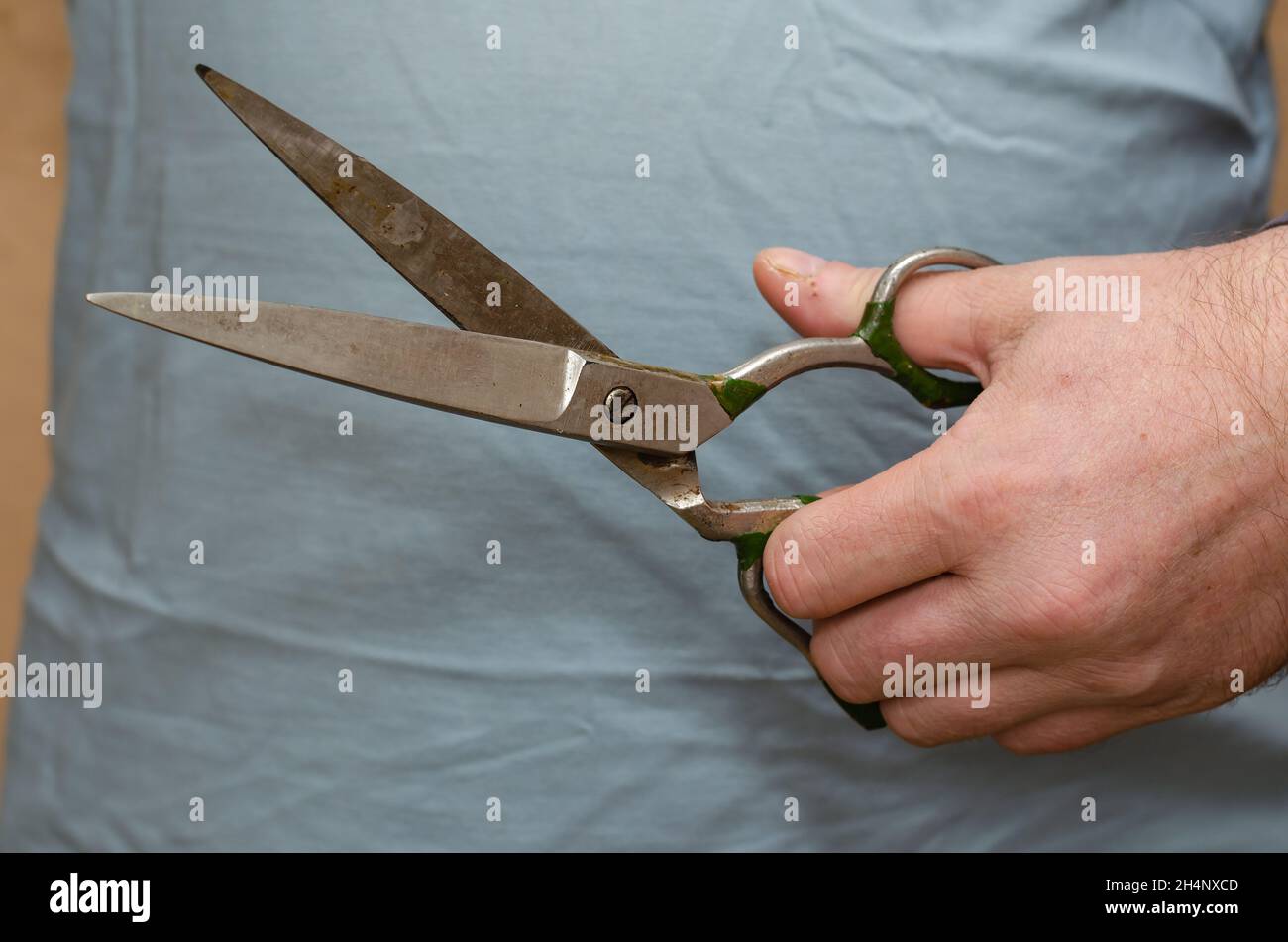The middle section of the man holding the old open scissors. Hand ...