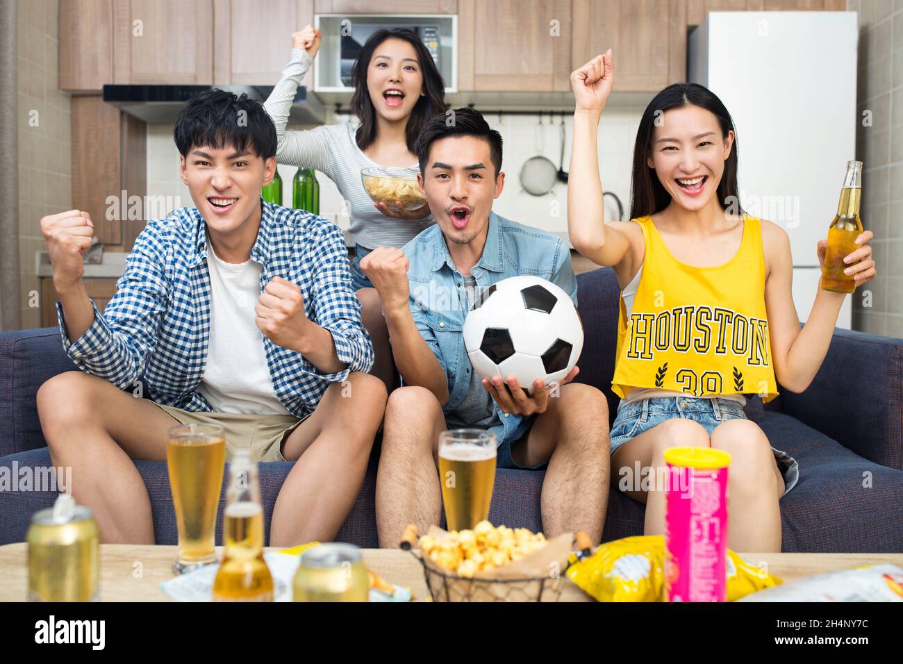 Young people watching sports games in the living room Stock Photo - Alamy