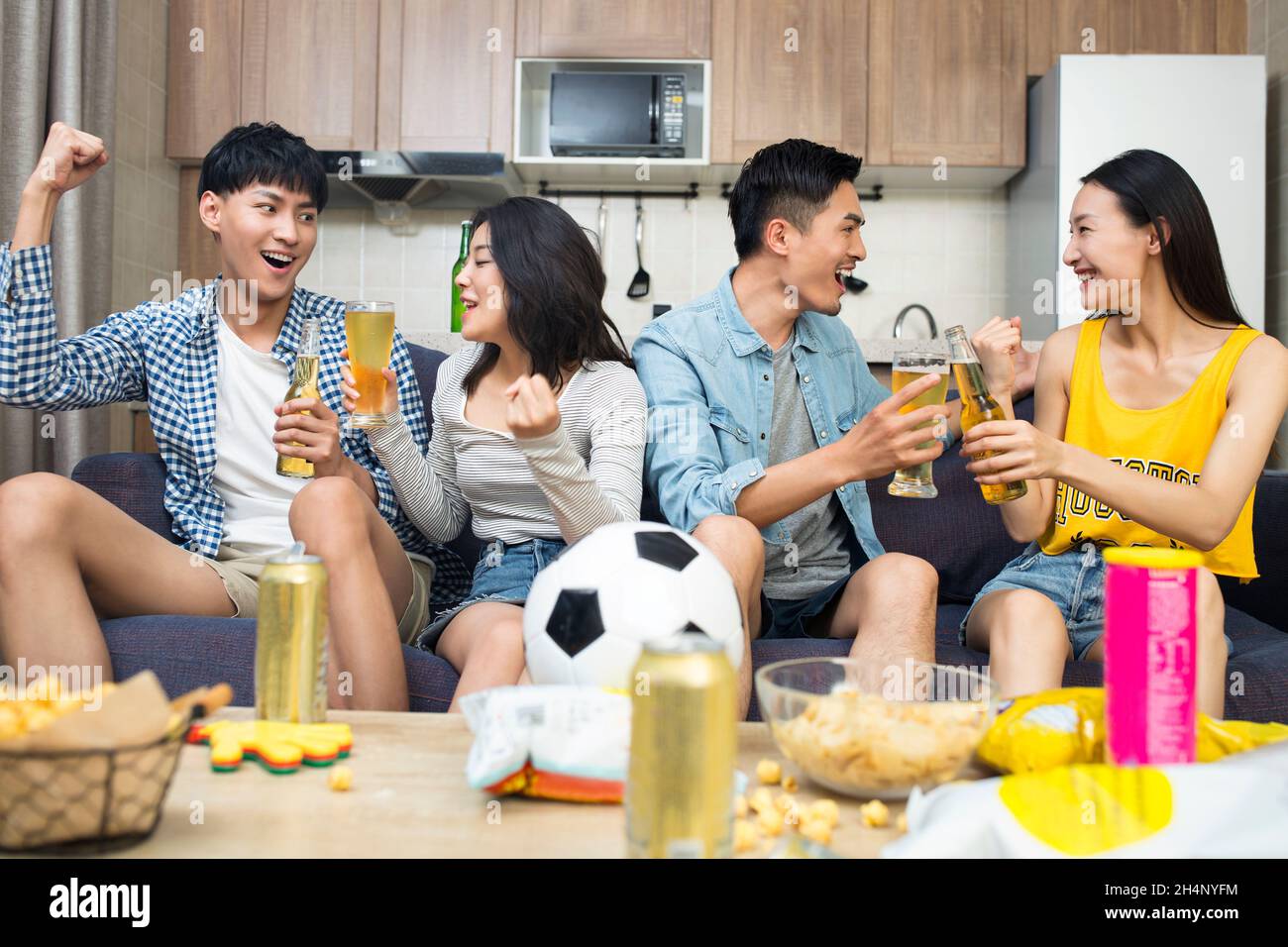 Young people watching sports games in the living room Stock Photo - Alamy