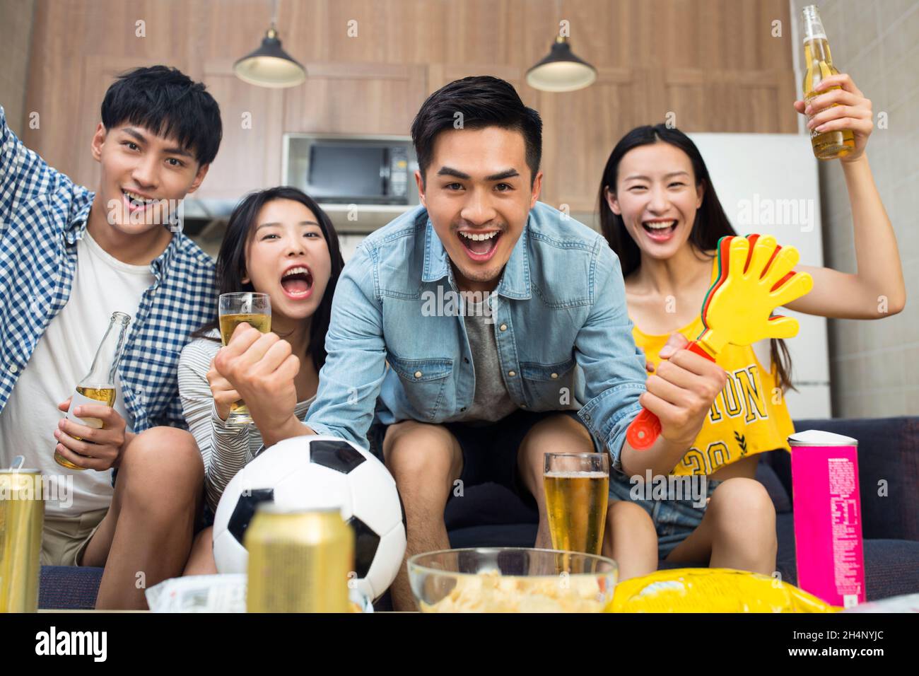 Young people watching sports games in the living room Stock Photo - Alamy