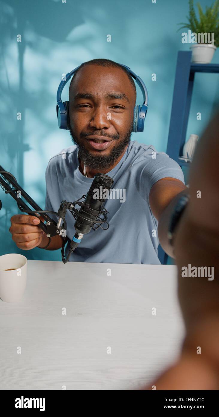 Vertical video: POV of vlogger holding camera to film video in studio ...