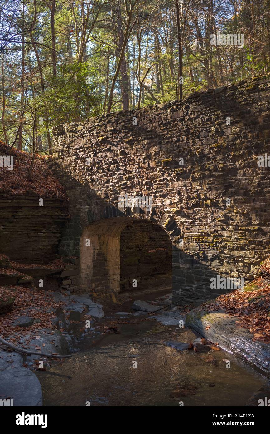 Vertical landscape of a stone arch bridge spanning over a small creek ...
