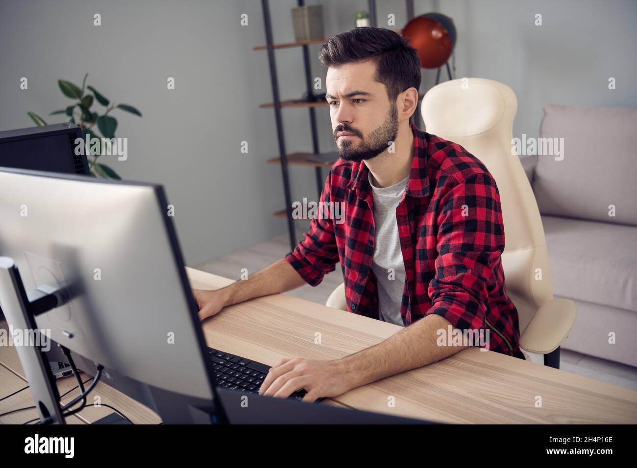 Photo of focused serious young man sit table work office business look ...