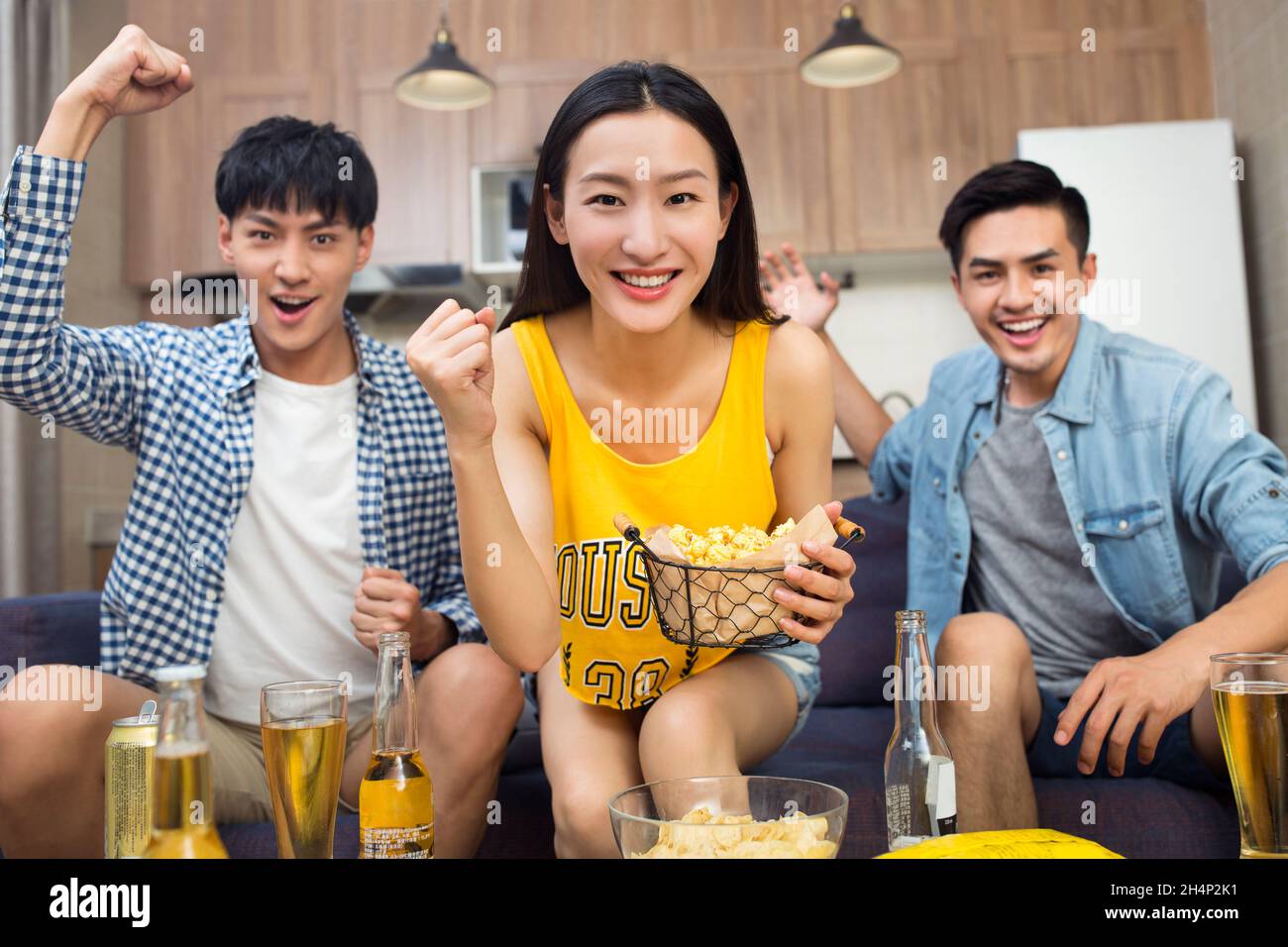Young people watching sports games in the living room Stock Photo - Alamy