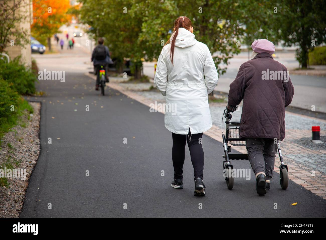 Back view of a senior pedestrian and a young woman walking on the ...